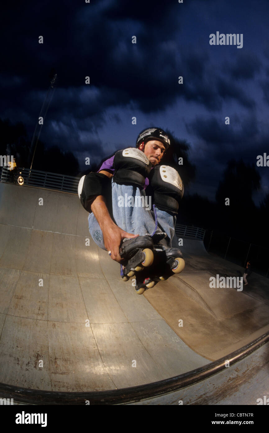 Teenage boy inline skating on the vert ramp Stock Photo - Alamy