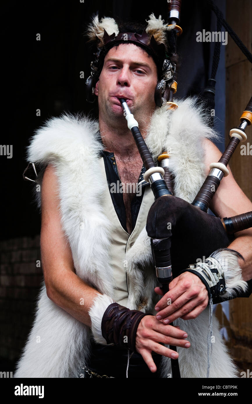 Man dressed in animal furs, playing the bagpipes in High Street ...