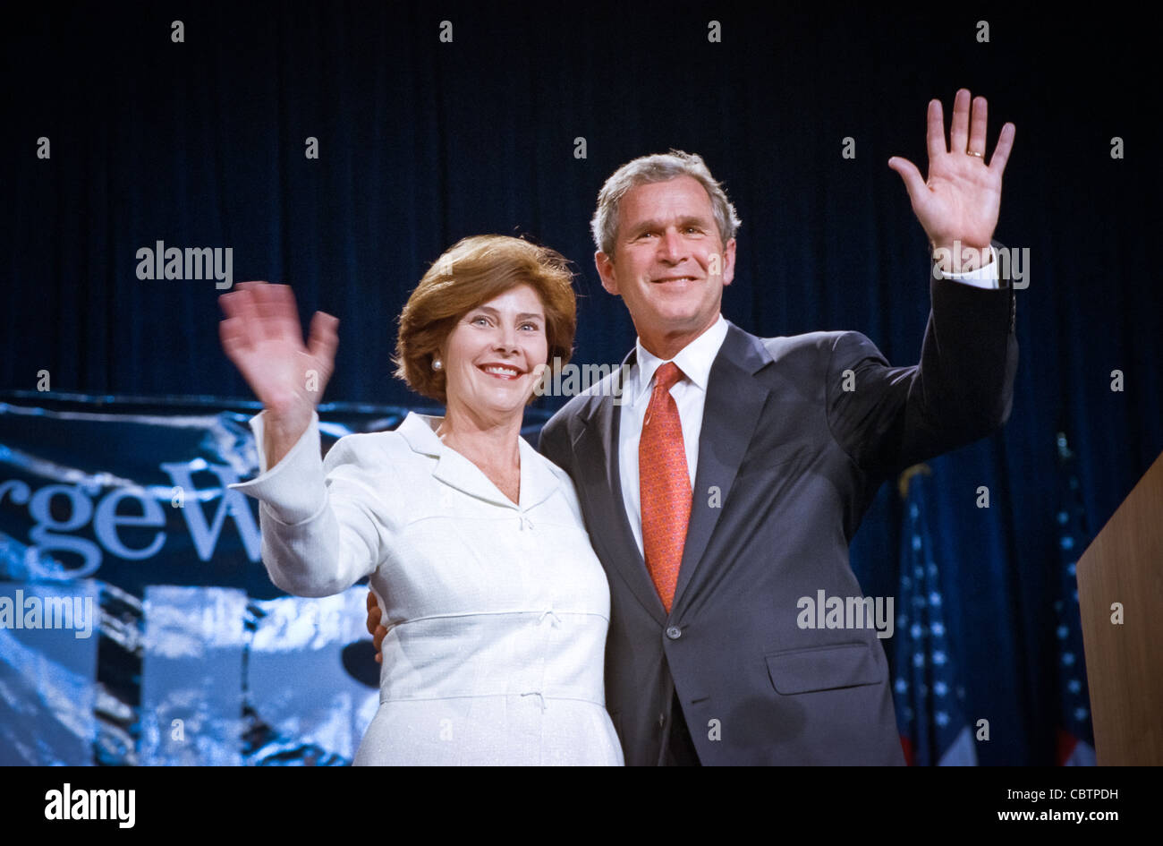 Texas Gov. George W. Bush and his wife Laura wave, during a campaign ...