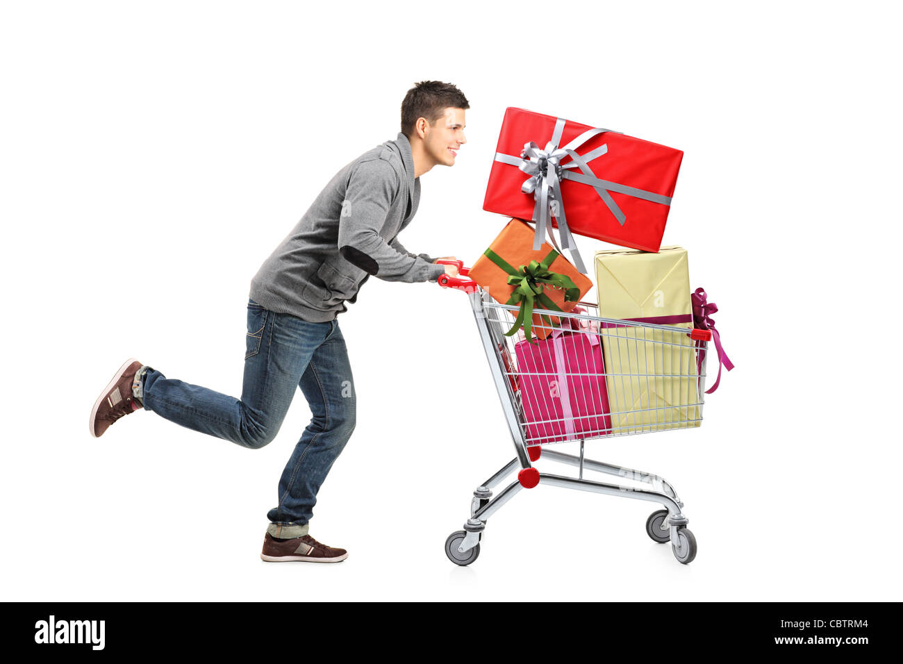 Young man running and pushing a shopping cart with gifts Stock Photo ...