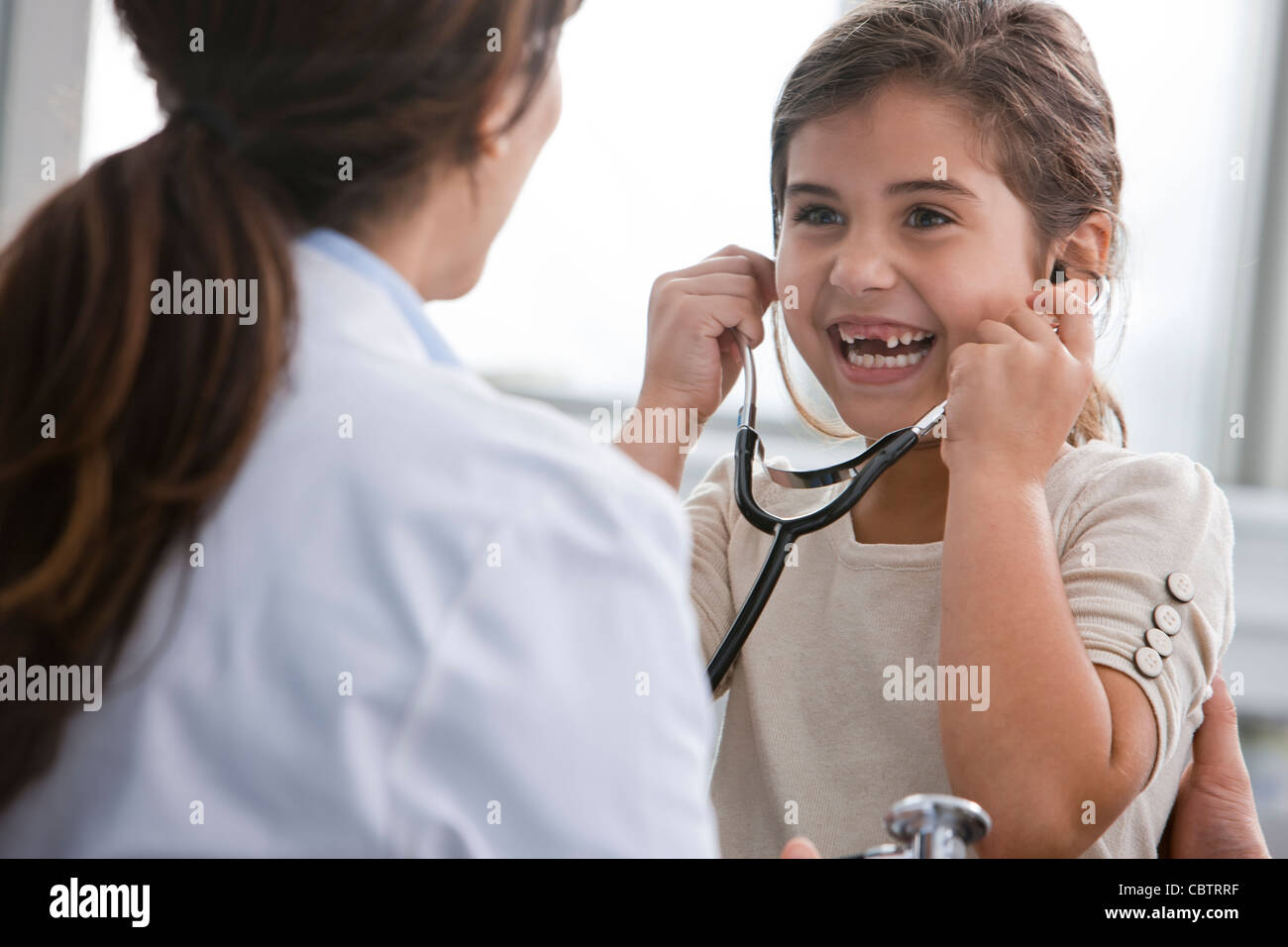 Doctor letting girl use stethoscope Stock Photo - Alamy