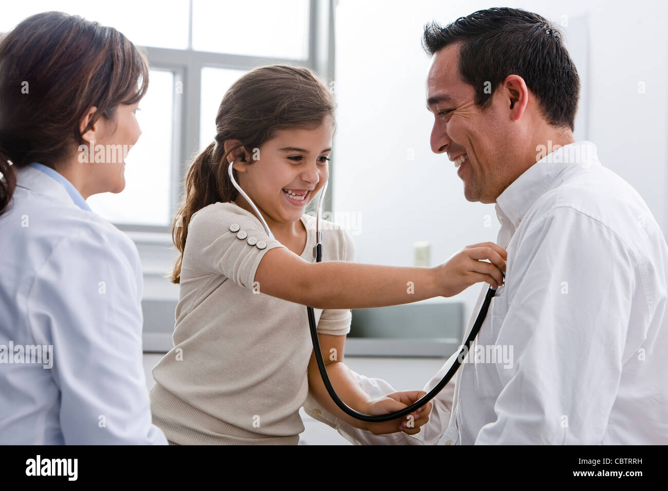 Doctor letting girl use stethoscope Stock Photo - Alamy