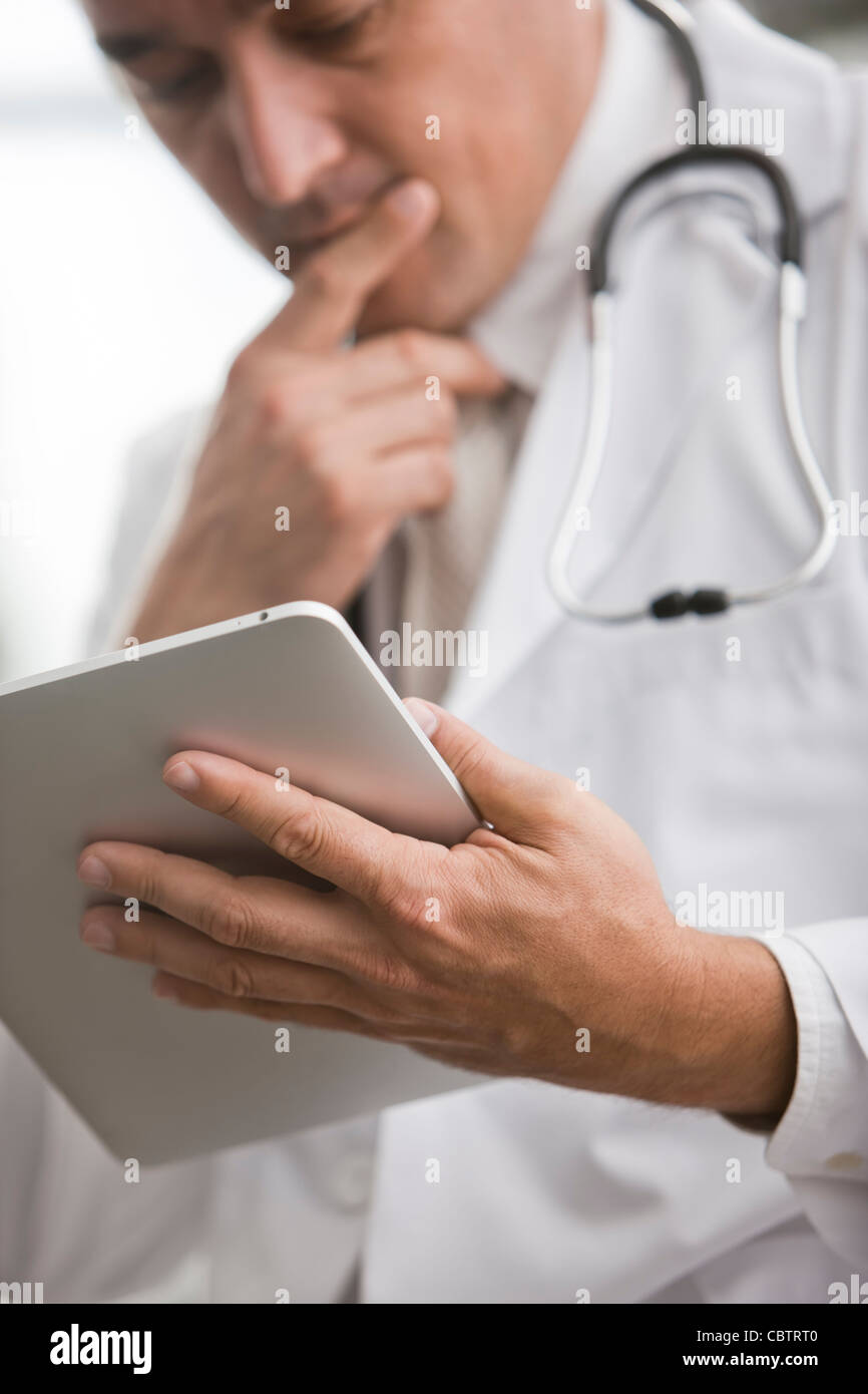 Mixed race doctor using digital tablet Stock Photo - Alamy