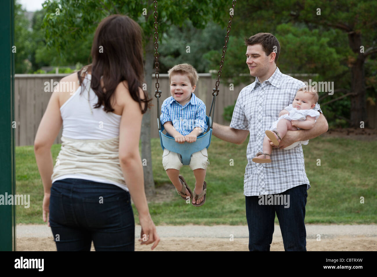 Family having fun with their children in playground Stock Photo - Alamy