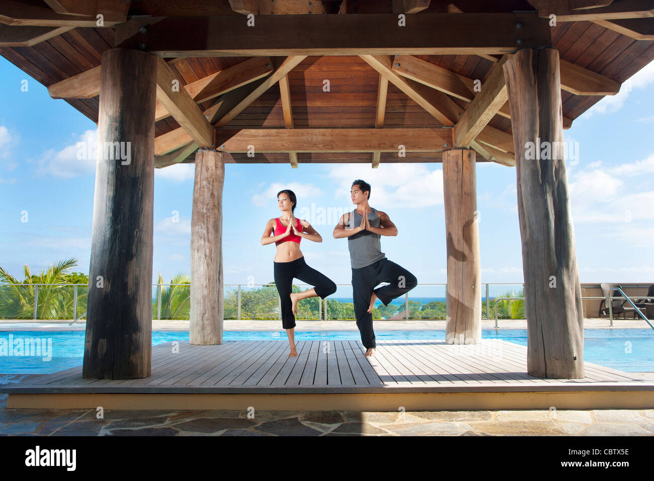 Couple practicing yoga together Stock Photo - Alamy