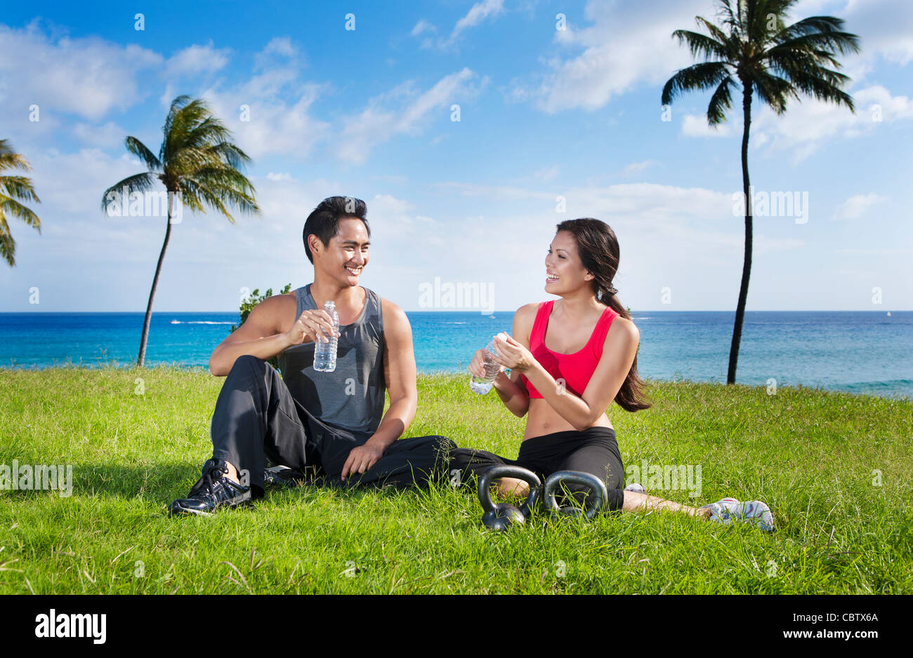 Couple drinking water after exercise at waterfront Stock Photo - Alamy