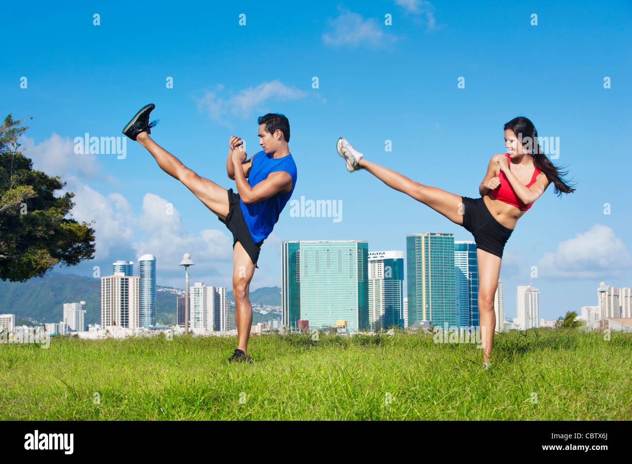Couple exercising together in field Stock Photo - Alamy