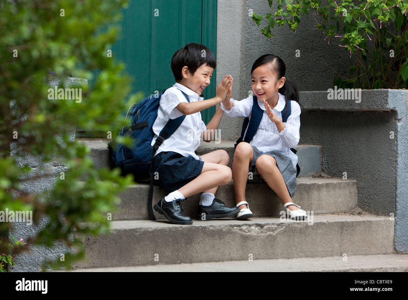 Two school children playing outside Stock Photo - Alamy