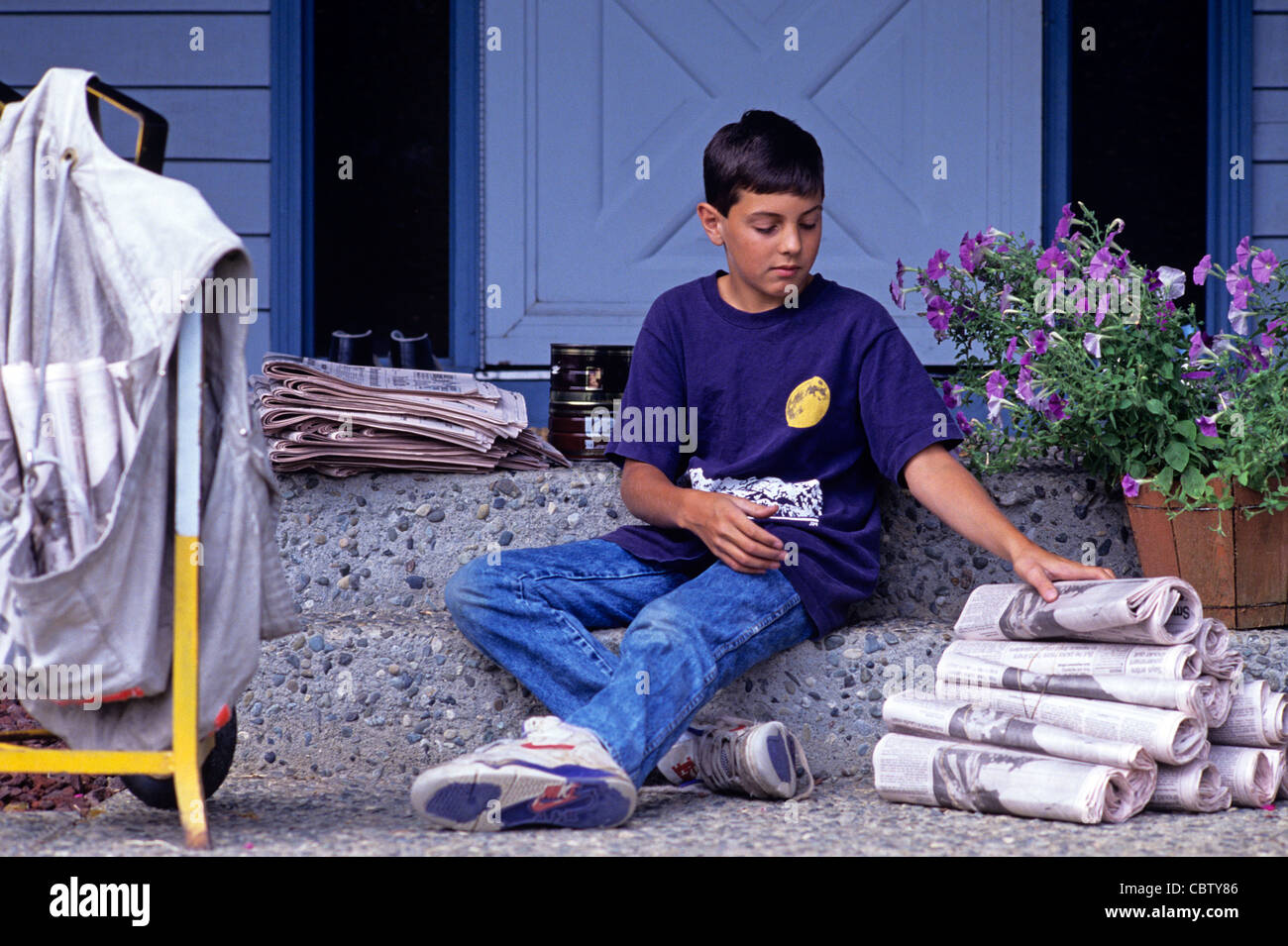 Young boy (9-10 yrs old) preparing papers for his paper route Stock ...