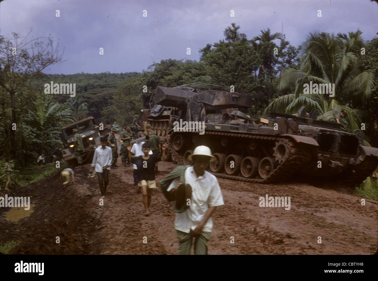 Muddy road and local Vietnamese outside quan loi vietnam war base camp ...