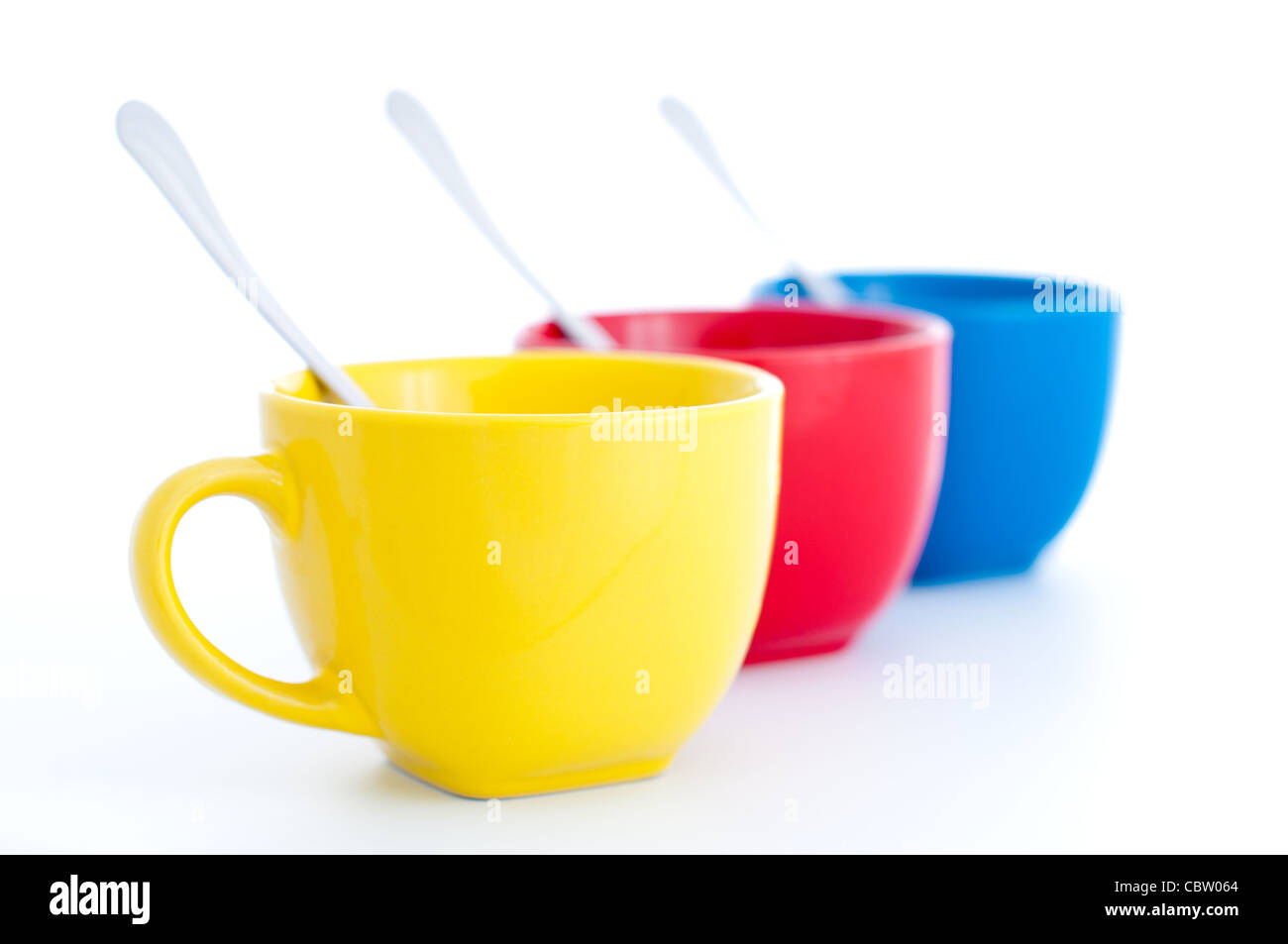 three colorful tea cups with spoons isolated on white background Stock ...