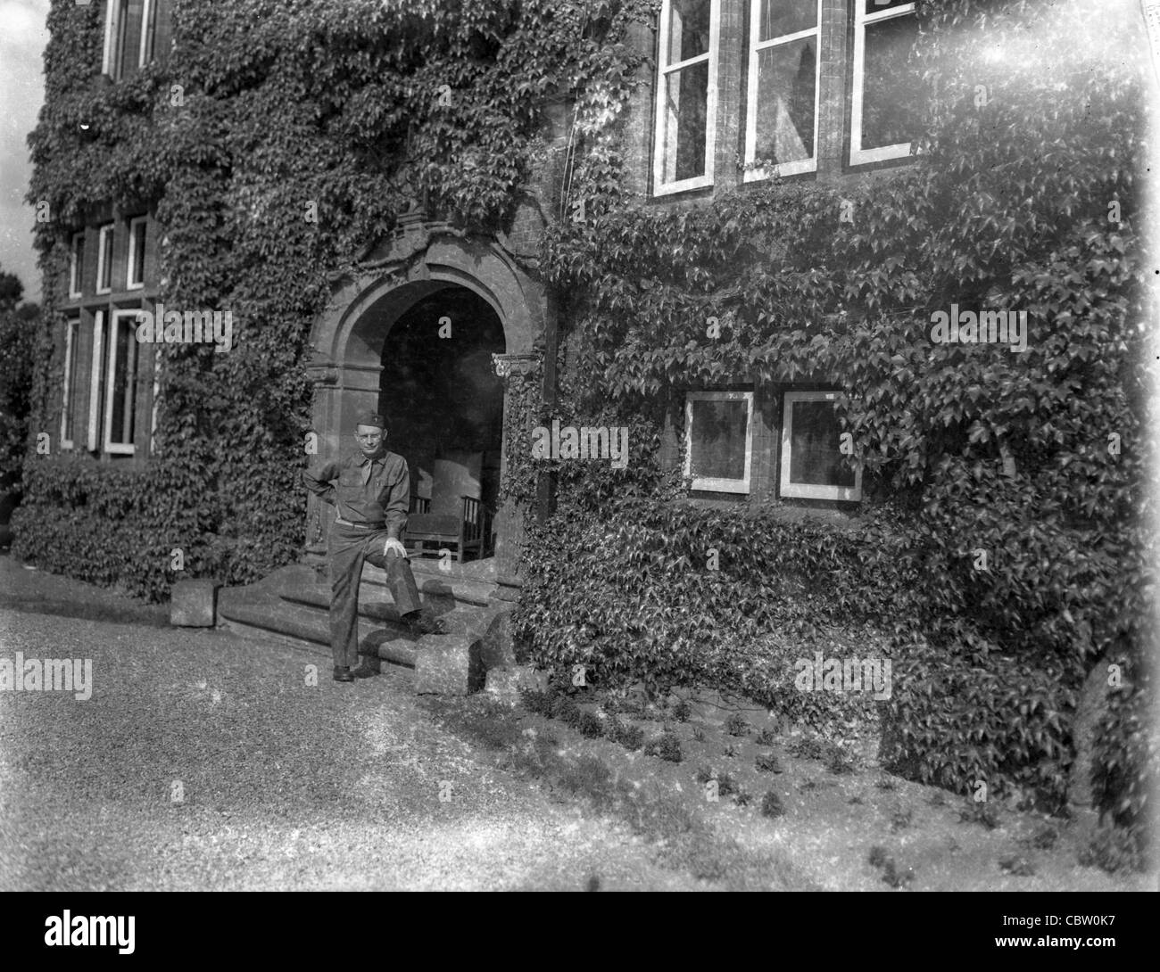 American Soldier GI standing outside building covered with Ivy in ...