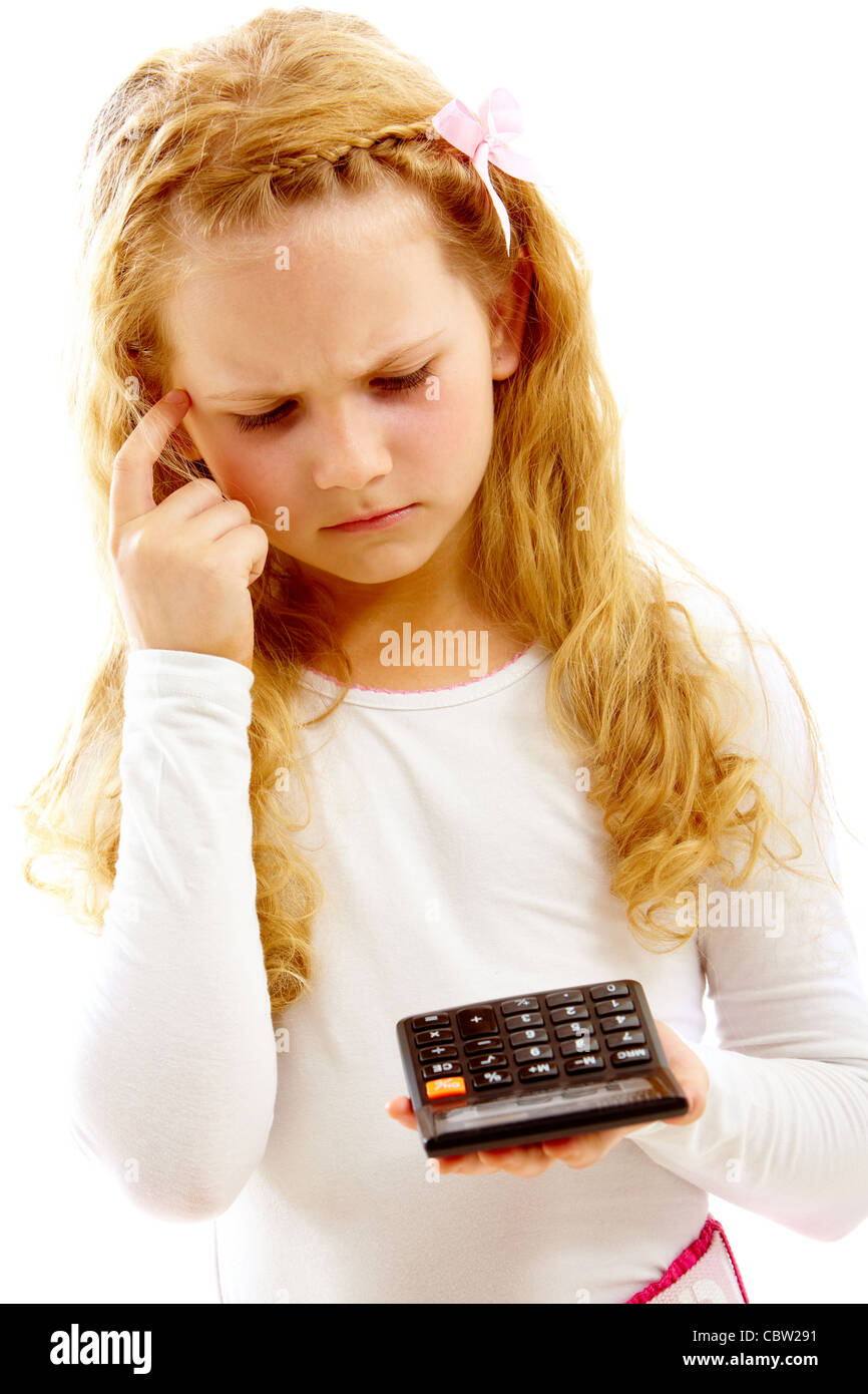 Portrait of cute girl looking at calculator while doing sums Stock ...