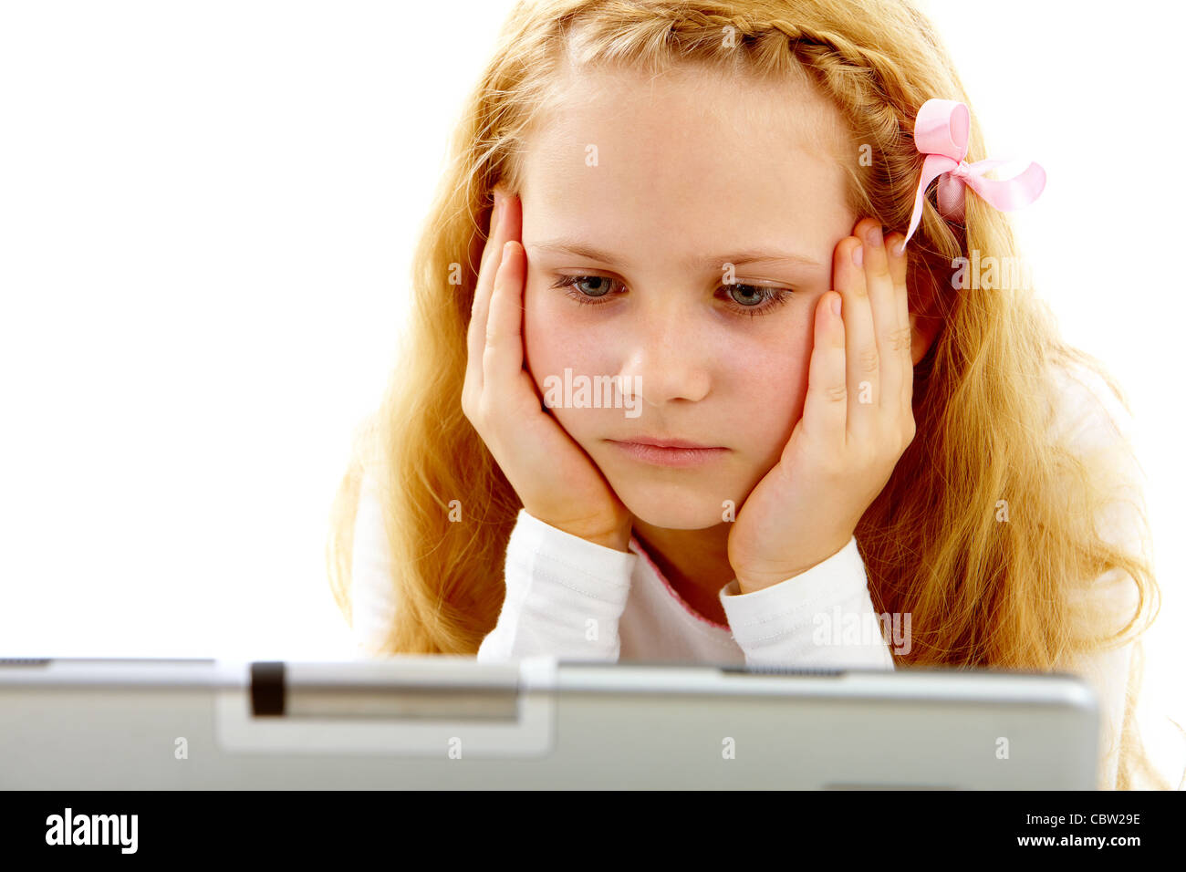 Portrait of cute girl looking at laptop screen Stock Photo - Alamy