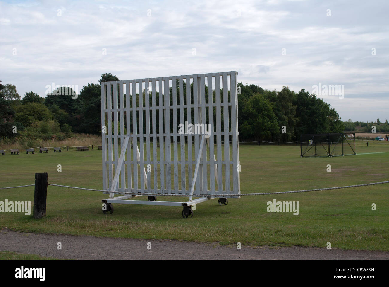 Cricket sight screen on the edge of a cricket pitch with trees in the ...