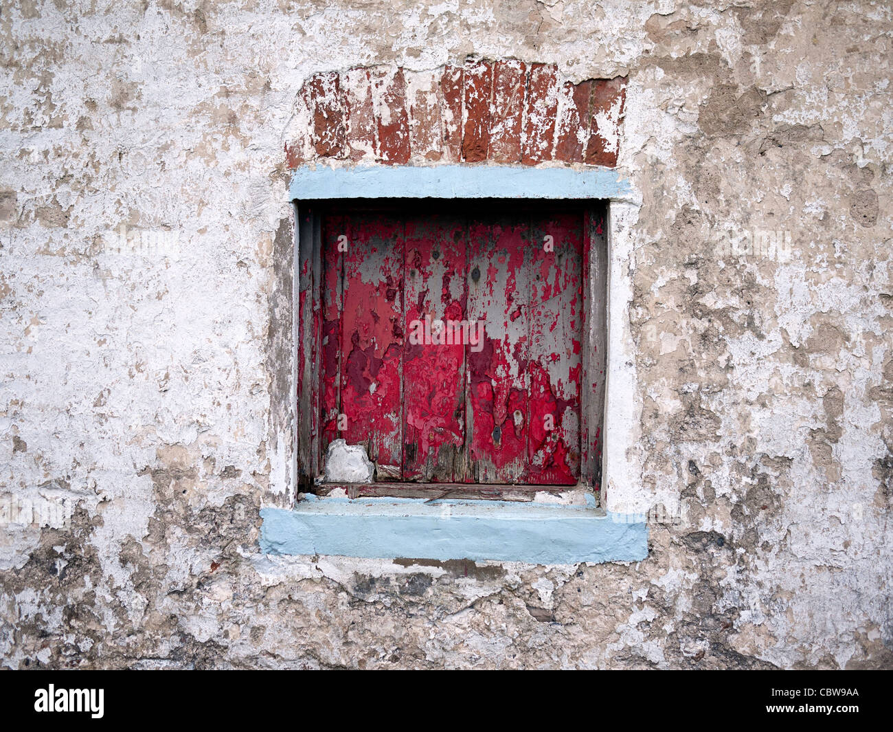 An old rotten window painted red set in an old stone building Stock ...
