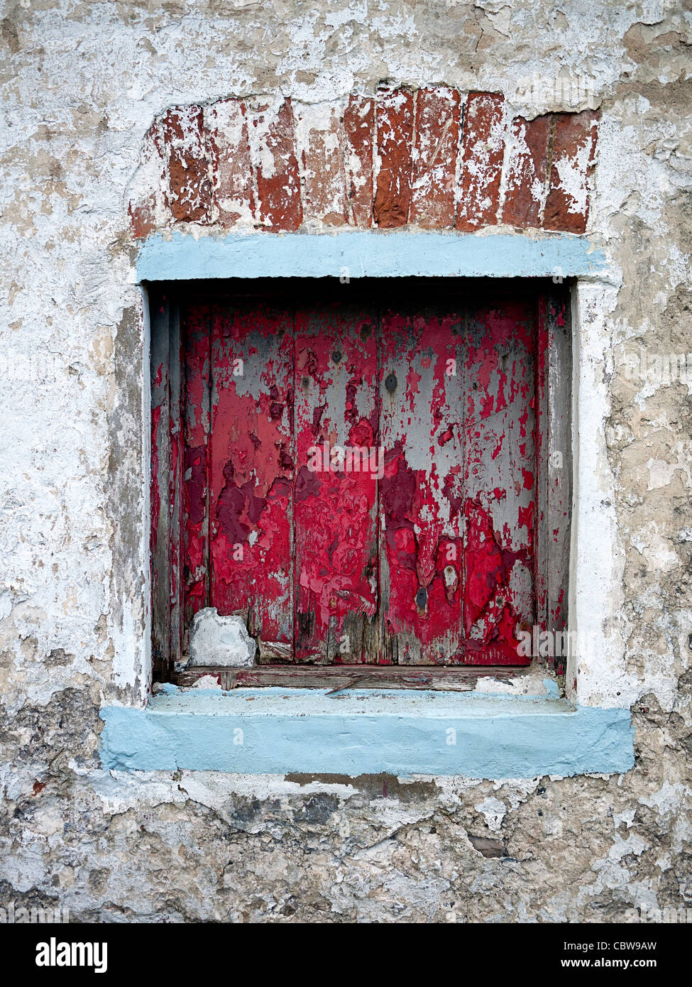 An old rotten window painted red set in an old stone building Stock ...
