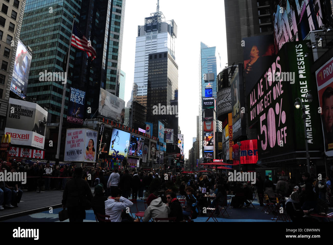 Theatre-goers queuing people sitting tables, neon billboard skyscrapers, Duffy Square, 7th ...