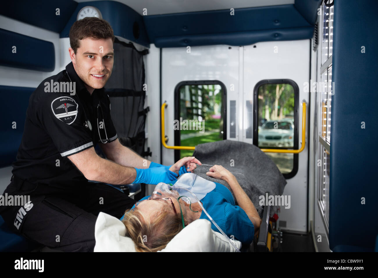Portrait of a male EMT inside ambulance with senior woman patient Stock ...