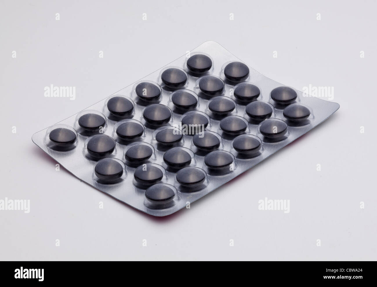 Black Pills in blister on gray Stock Photo - Alamy
