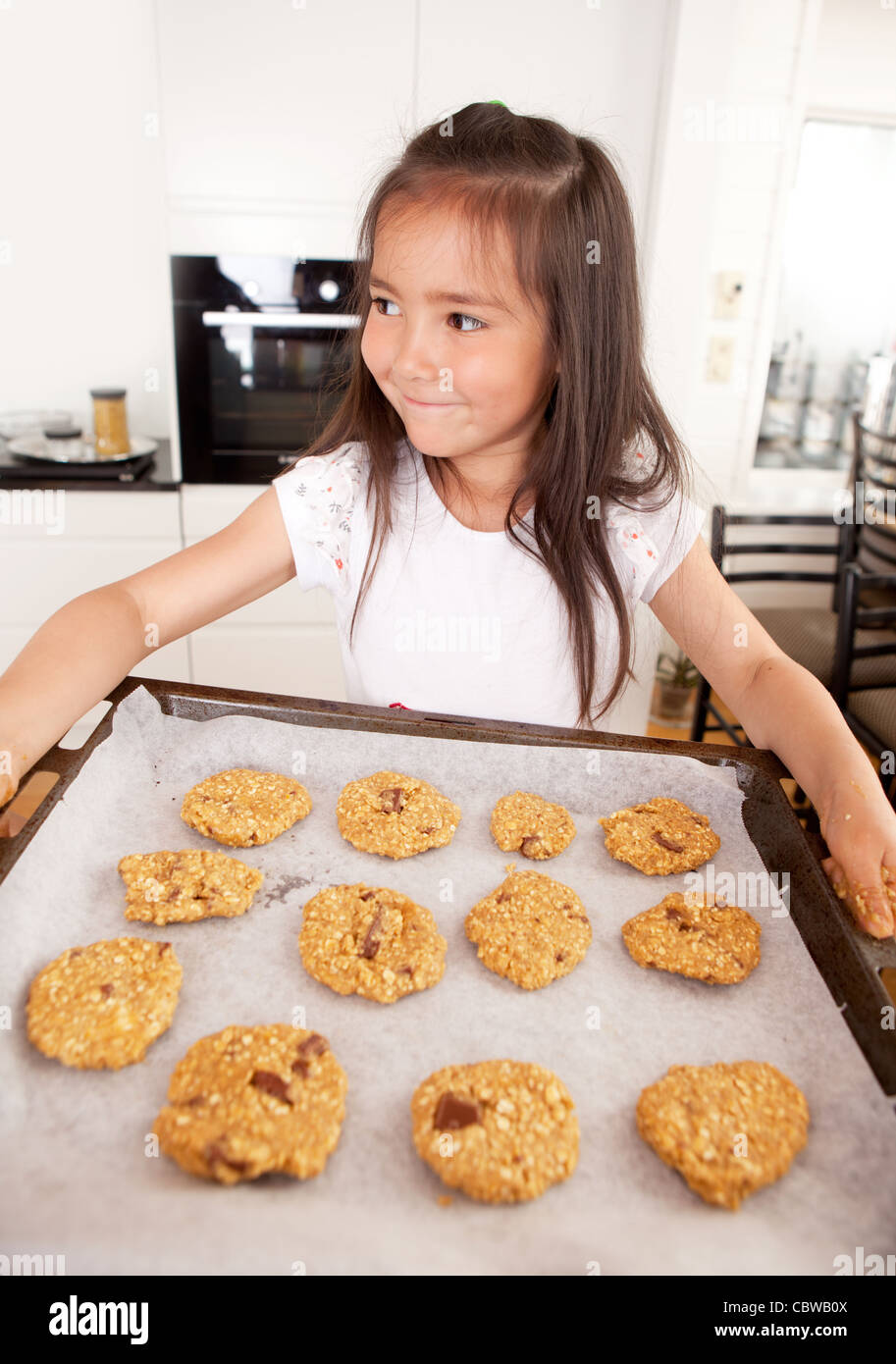 Young girl with cookie sheet filled with raw cookies Stock Photo - Alamy