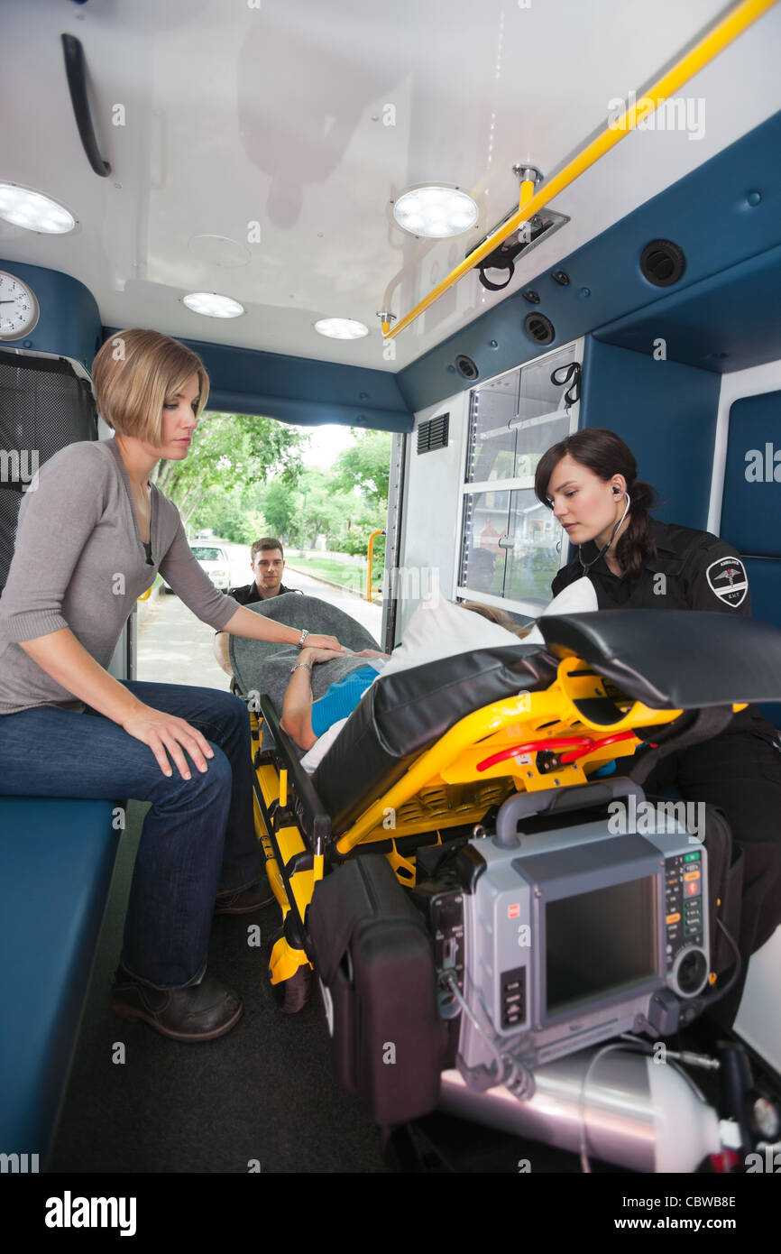 EMT professional caring for a senior woman in an ambulance, caregiver ...