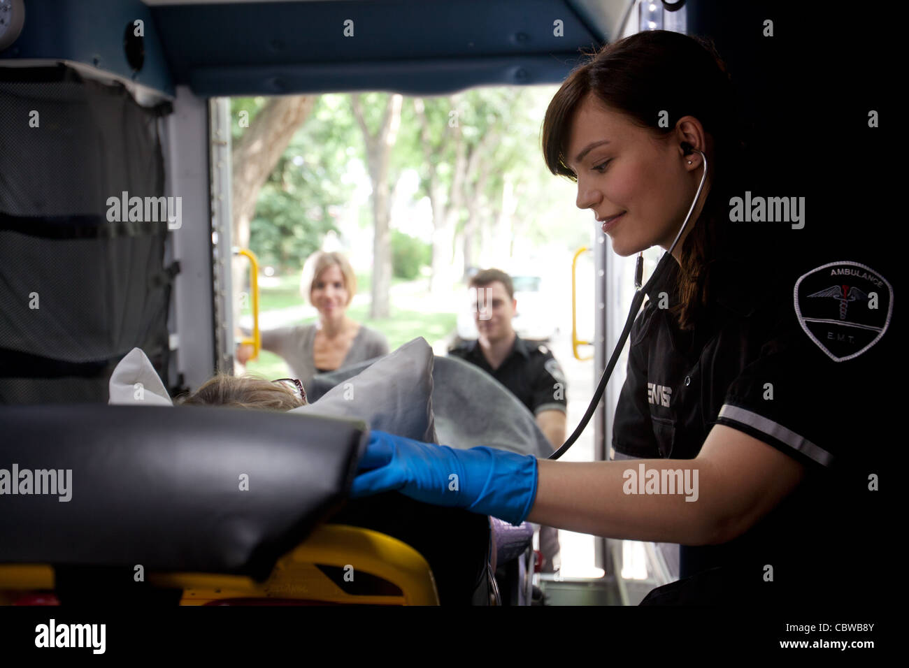 Paramedic listening to heart rate of patient in ambulance Stock Photo ...