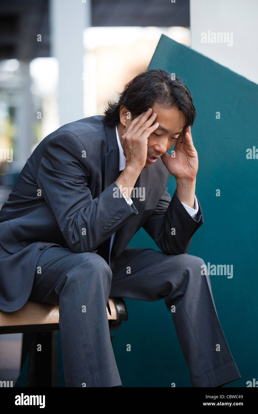 Business man sitting on bench outdoors not feeling well Stock Photo - Alamy
