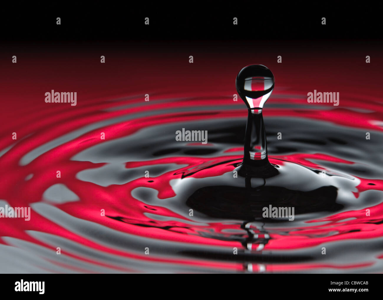 Water drop caught in motion red highlights Stock Photo - Alamy