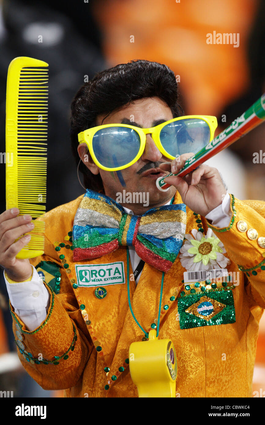 A costumed Brazil supporter displays a large comb and sunglasses at a ...