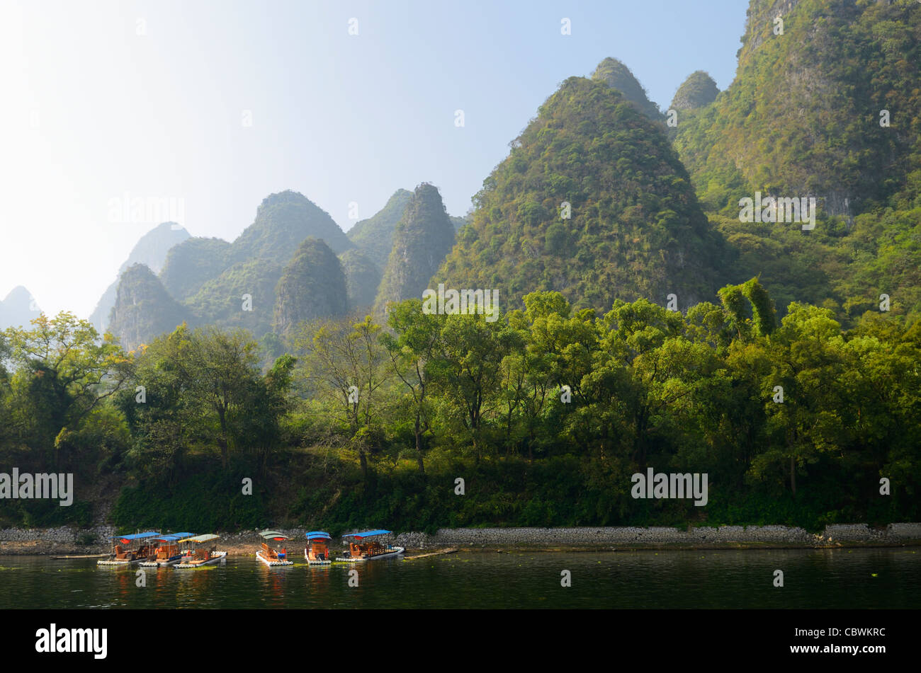 Tour boat rafts on the Li River Guangxi China with karst dome mountains ...