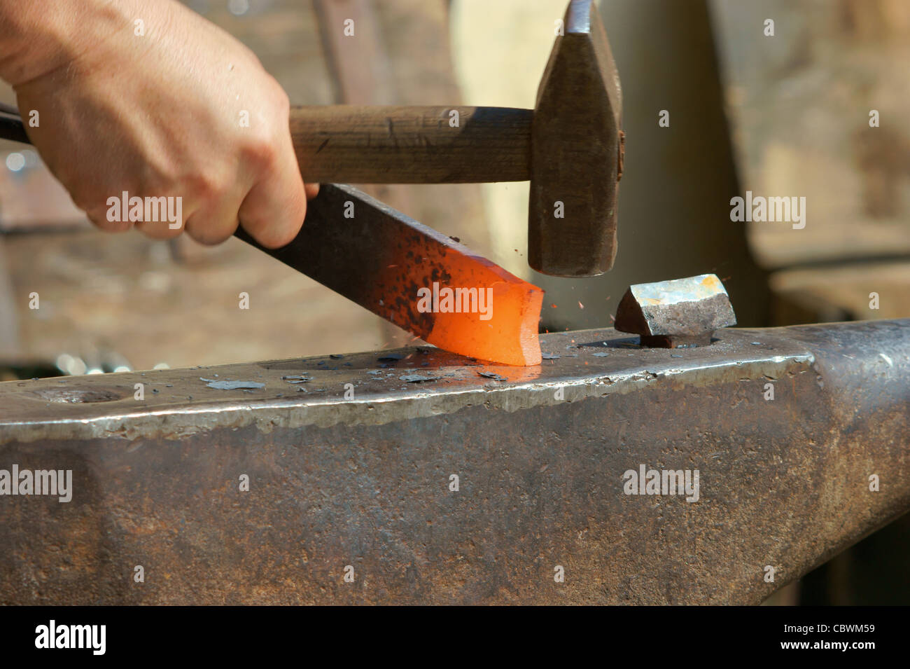 Hammering glowing steel - to strike while the iron is hot Stock Photo ...