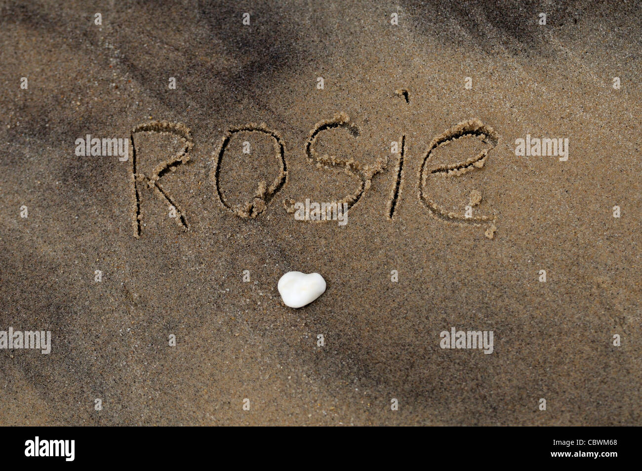 Girls name written in the sand above a heart shaped stone Stock Photo ...