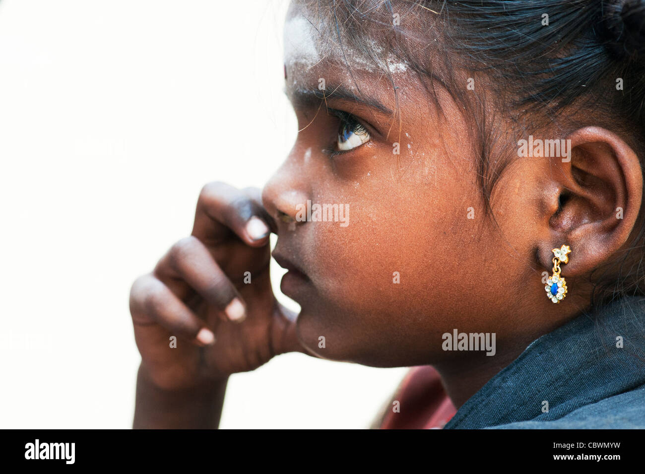 Poor Indian beggar girl with sacred ash on her face. Selective focus ...