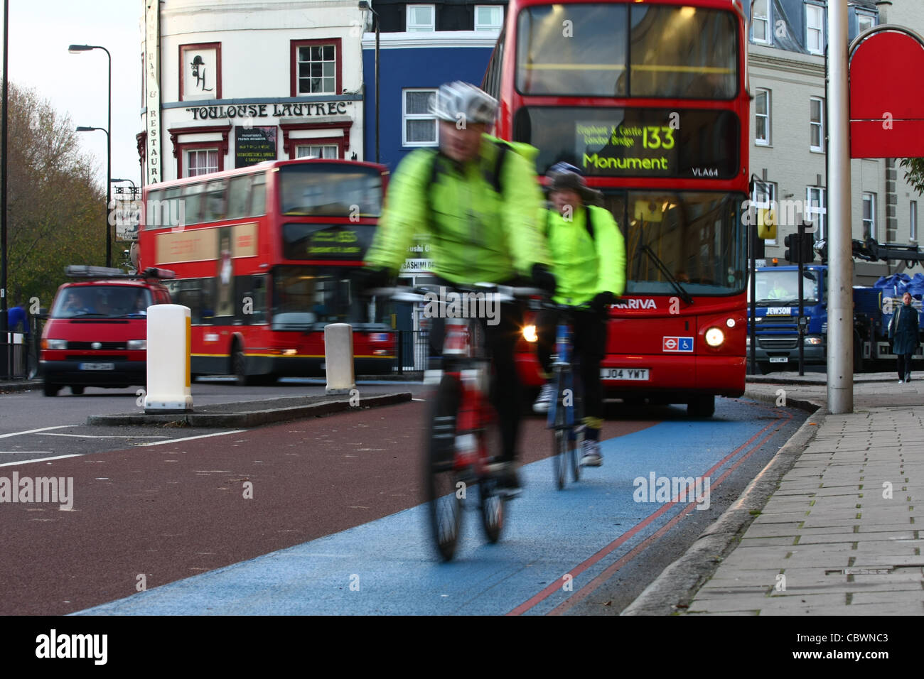 cyclists traveling along a cycle superhighway with traffic in the ...