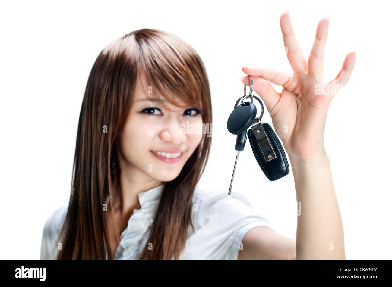 Young girl holding car key on white background Stock Photo - Alamy