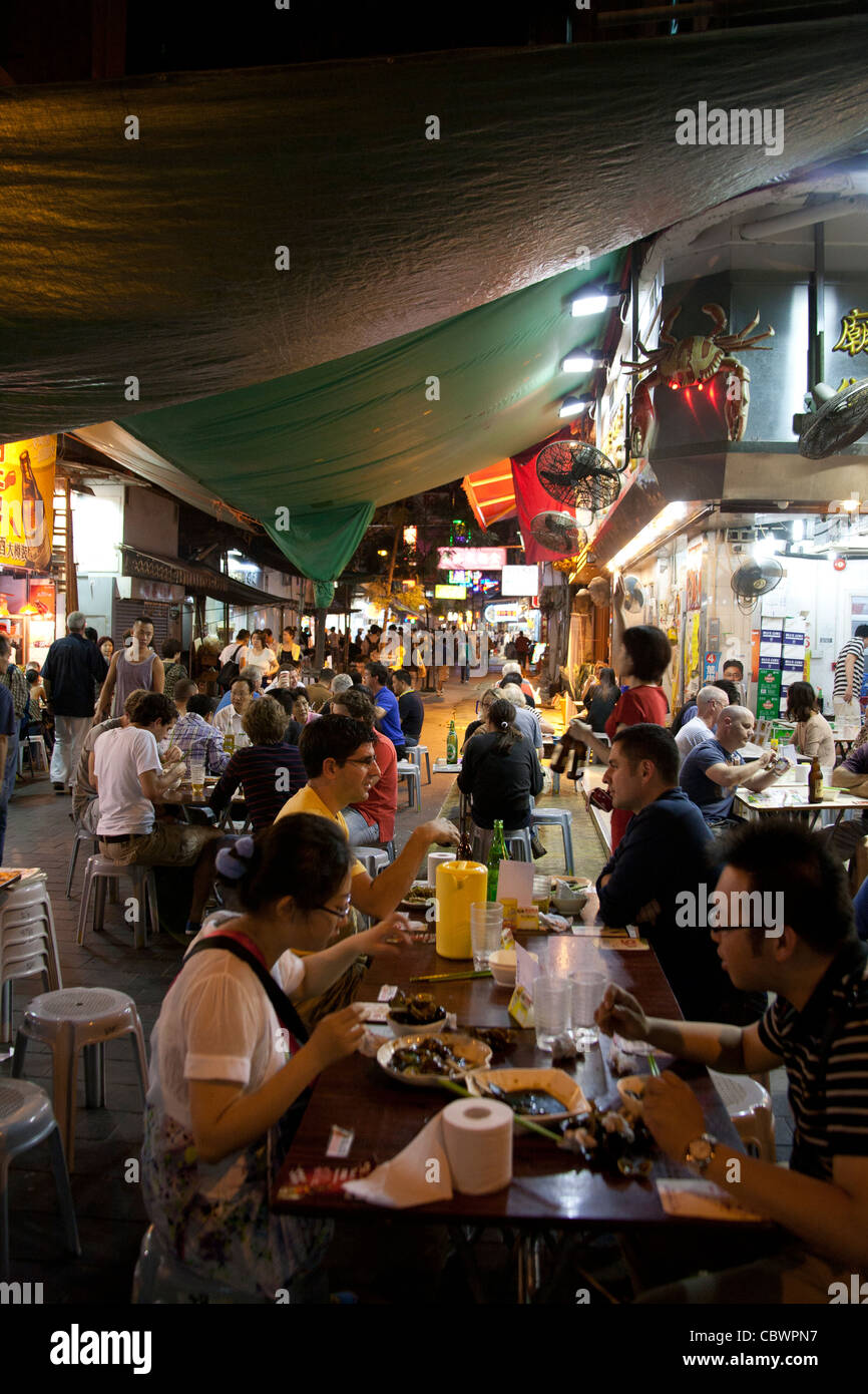 People eating at outside tables at night in the street cafes of Temple ...