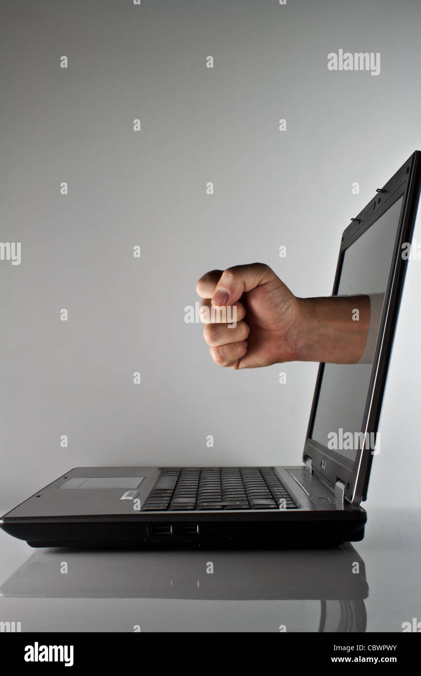 Photo of the laptop with a fist from the screen Stock Photo - Alamy