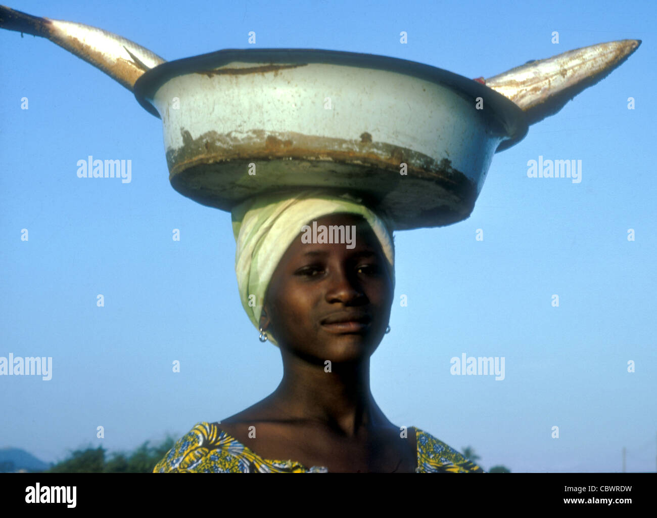 A young West African woman carrying a fish in a dish on her head Stock ...