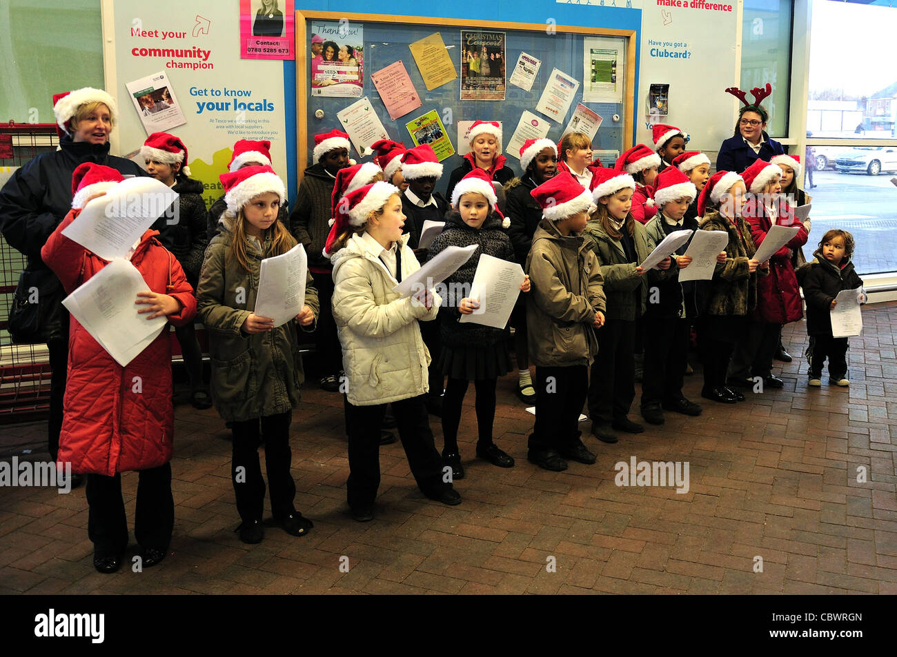 Primary school carol singers inside Tesco entrance, Gorton Stock Photo ...