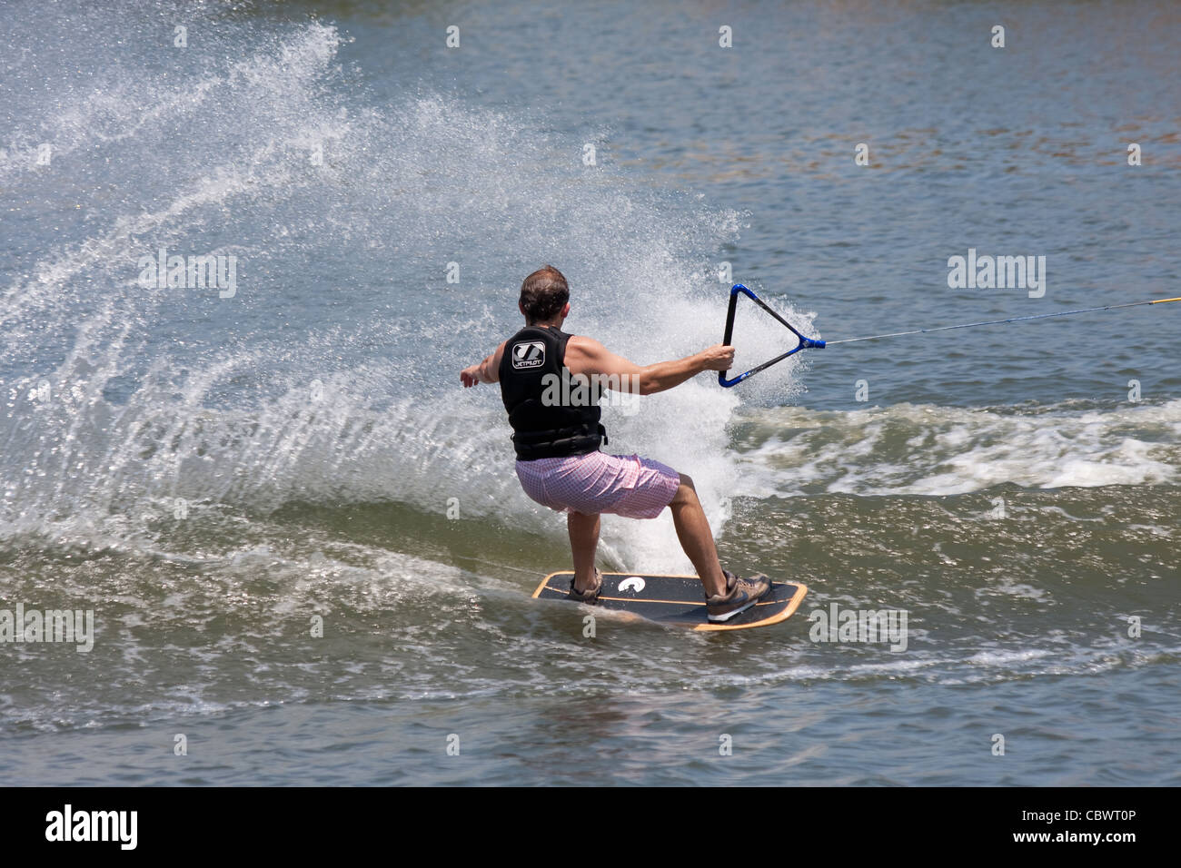 Man jumping the wake, stunts on a wakeboard, extreme sport Stock Photo ...