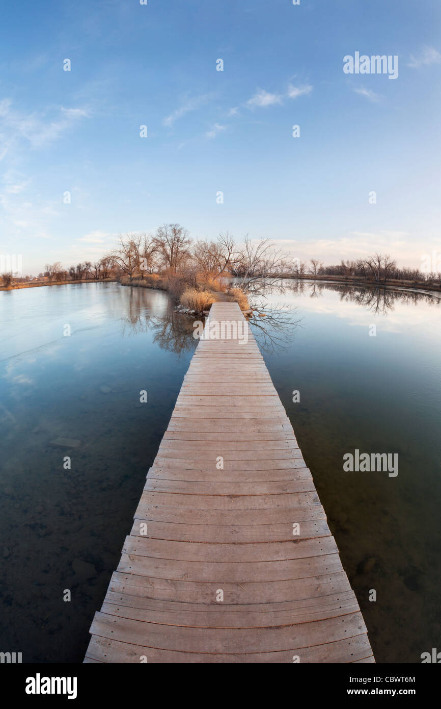pathway, journey or goal concept - boardwalk and trail across lake and ...
