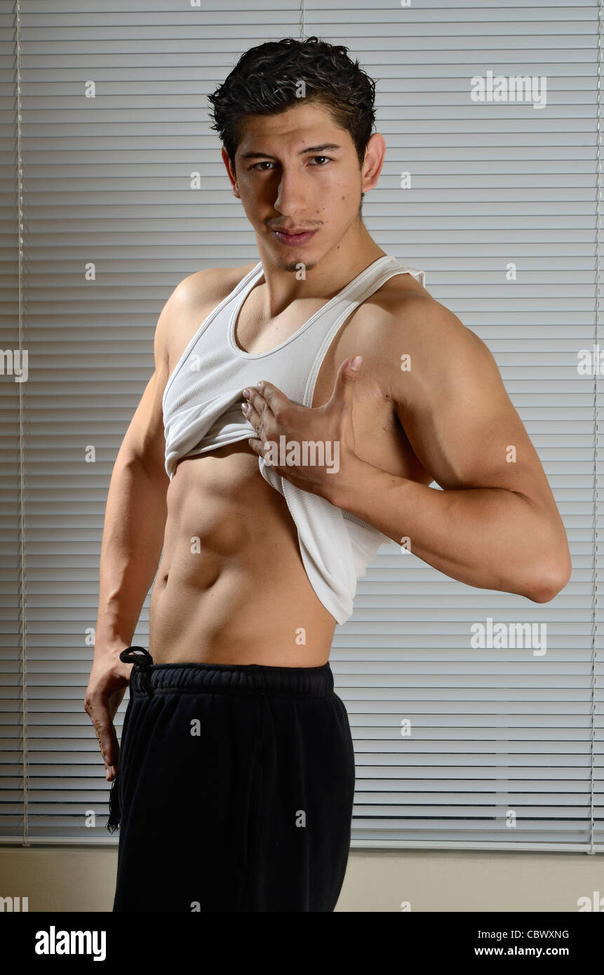 Young male model wearing a singlet and showing his abs Stock Photo - Alamy