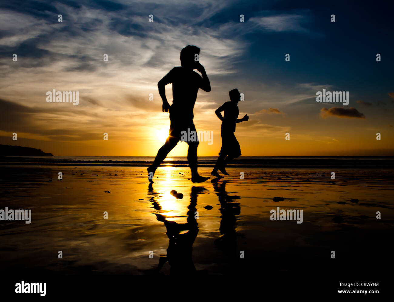 Two men shadows running on a beach at sunset Stock Photo - Alamy
