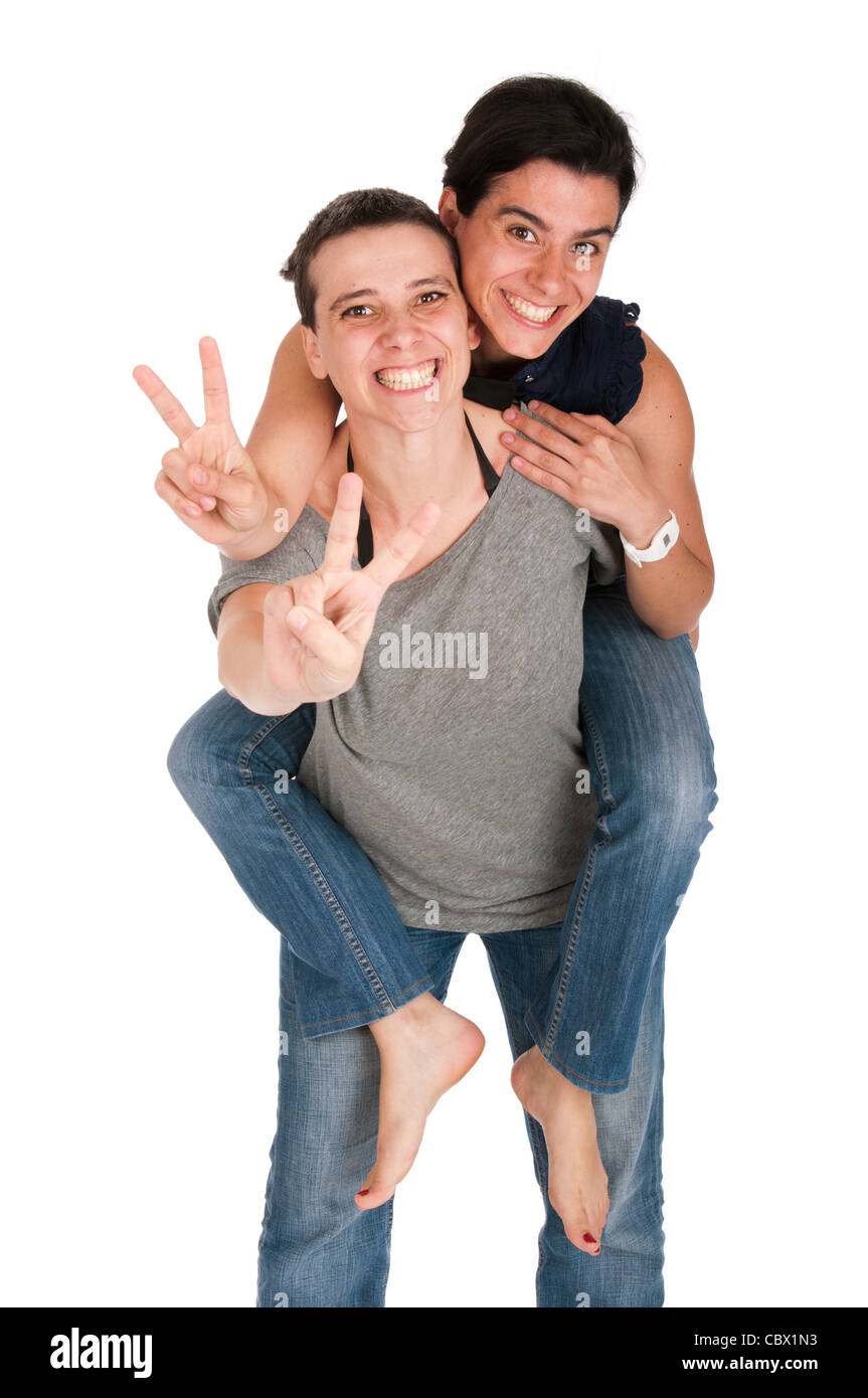 Sisters showing victory hand sign playing piggyback Stock Photo - Alamy