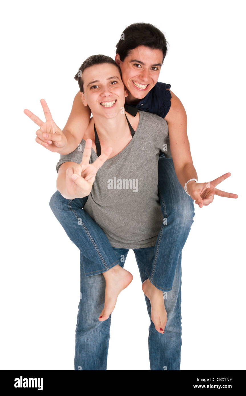 Sisters showing victory hand sign playing piggyback Stock Photo - Alamy