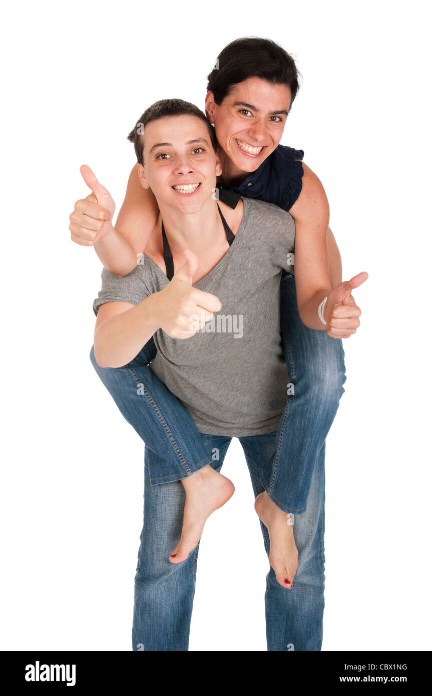 Sisters showing thumbs up sign playing piggyback Stock Photo - Alamy