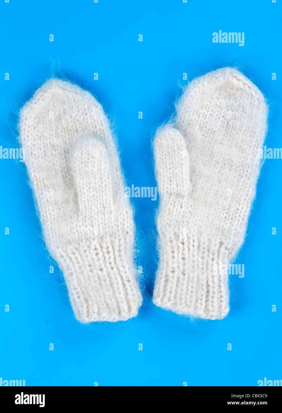 a pair of knitted wool mittens on a blue background Stock Photo - Alamy