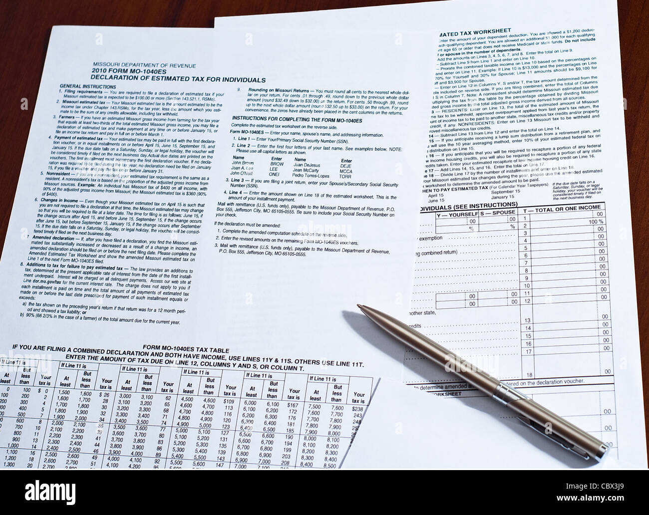 Filling out some business documents on a desk Stock Photo - Alamy