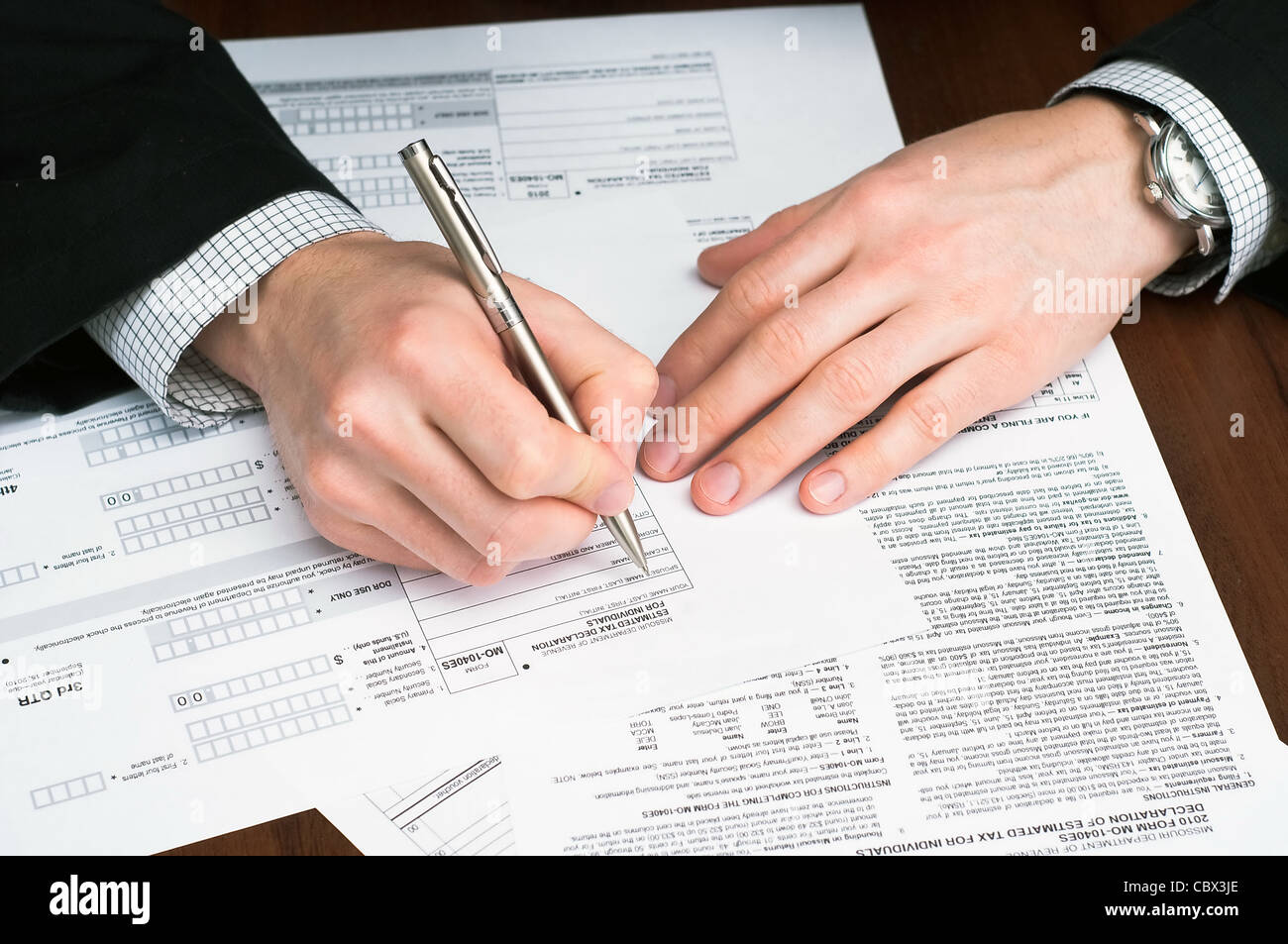 Filling out business documents on a desk Stock Photo - Alamy